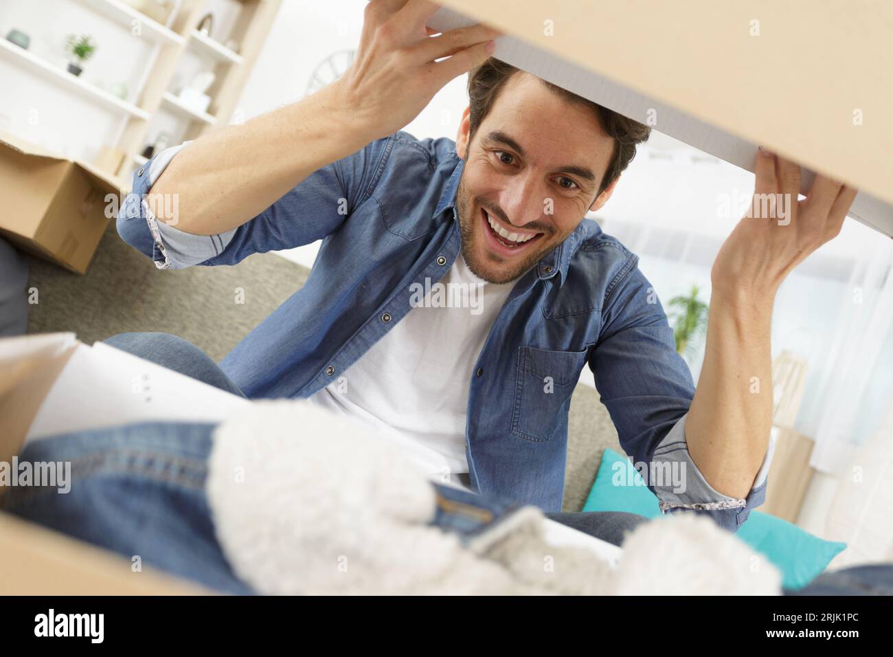Happy man opening parcel hi-res stock photography and images - Alamy