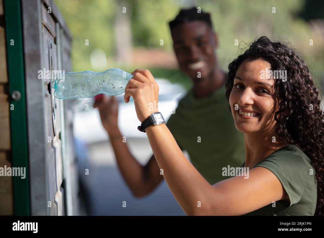 young couple recycling bottles together Stock Photo - Alamy