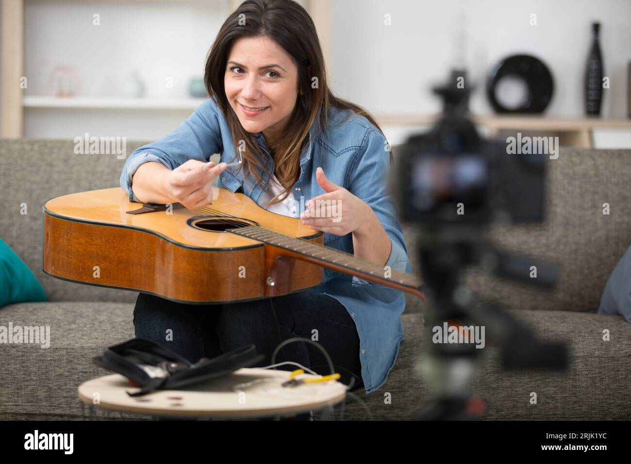 a female beautiful blogger is fixing guitar Stock Photo - Alamy