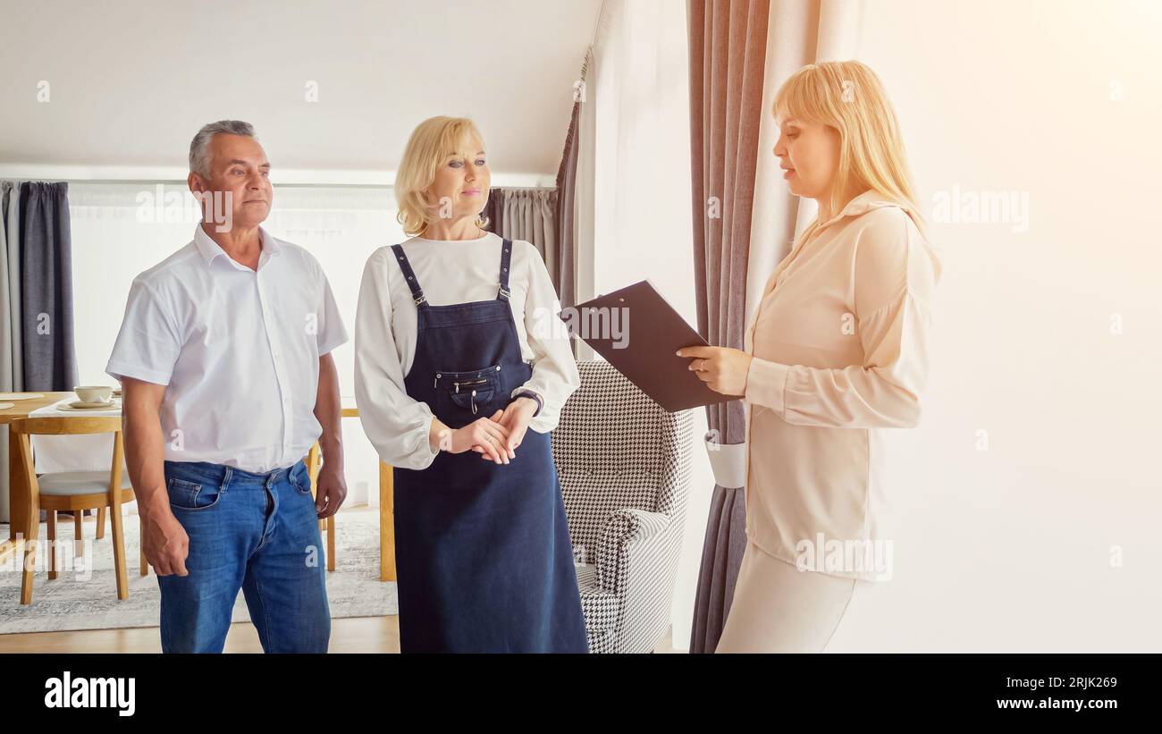 Professional lady realtor shows cottage residence to family Stock Photo ...
