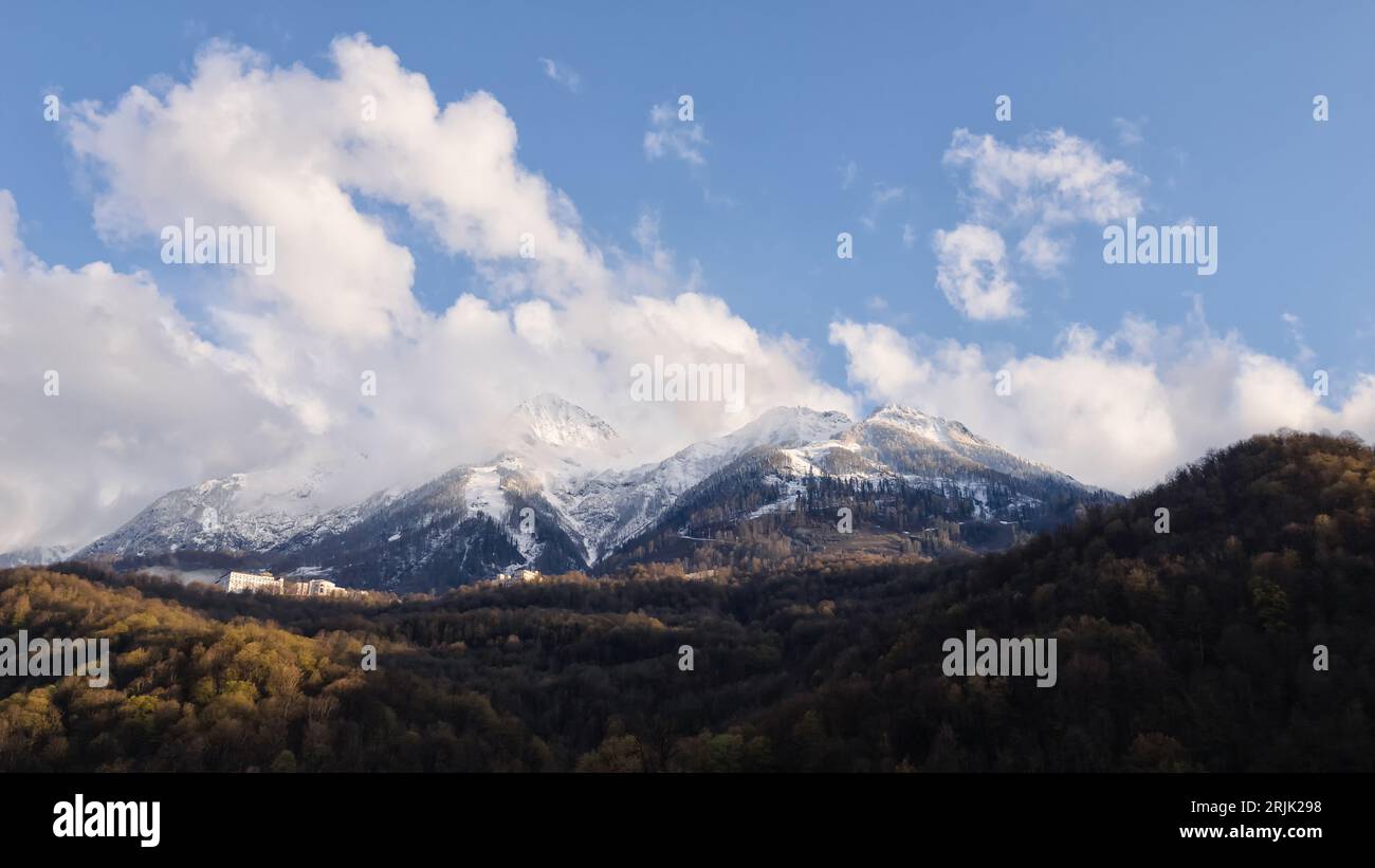 Cumulus clouds move over snowy peaks of high mountains Stock Photo - Alamy