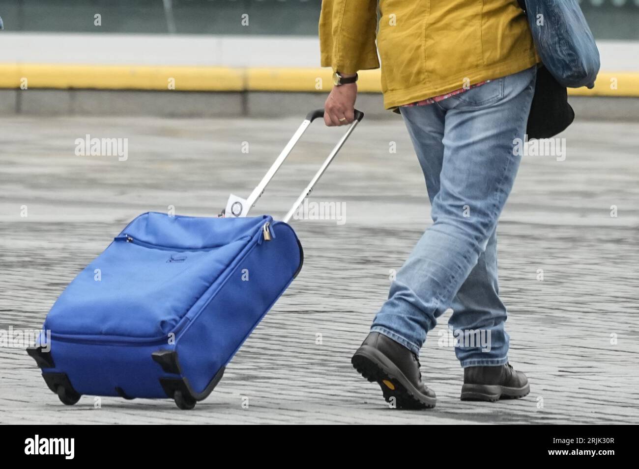 tourist pulling wheeled suitcase over cobbles Stock Photo - Alamy