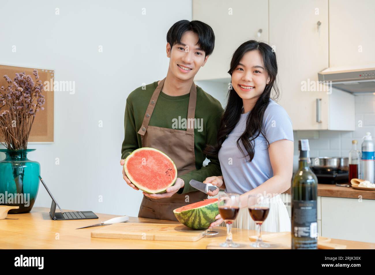 A happy and lovely young Asian couple is preparing healthy meals in the ...