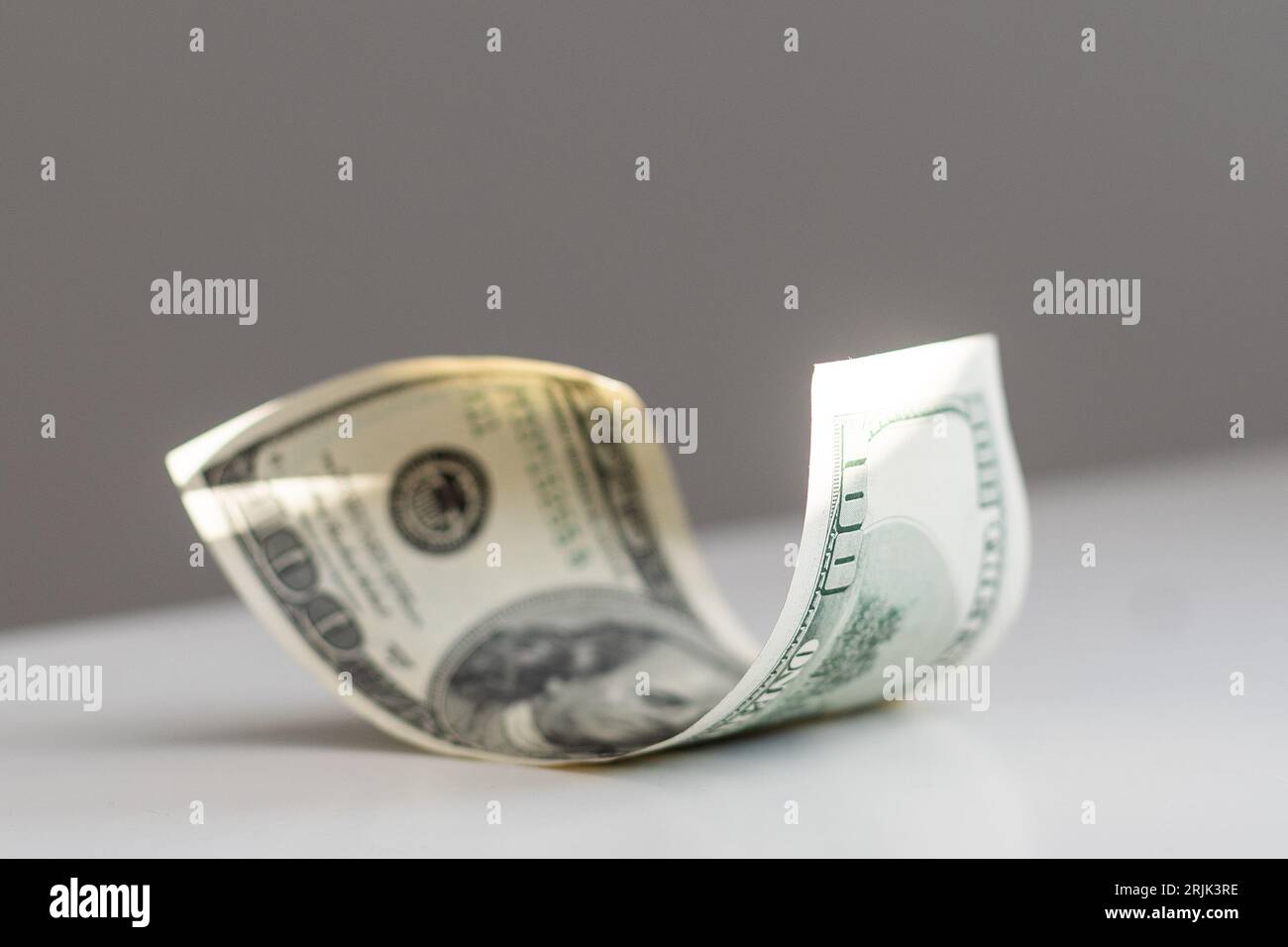 dollar bill curved wave isolated on white background Stock Photo - Alamy