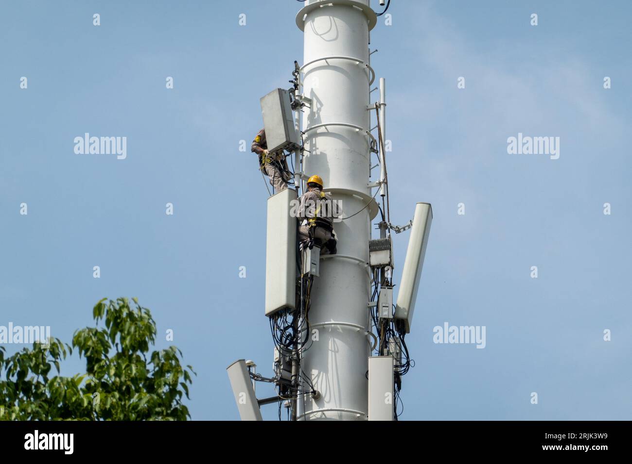 SHANGHAI, CHINA - AUGUST 23, 2023 - Construction workers work high above a communication base ...