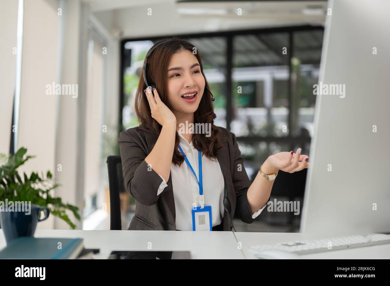 A professional and beautiful Asian female customer support agent is ...