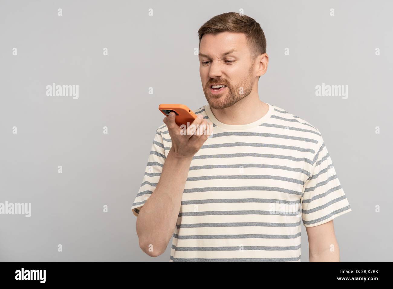 Angry annoyed man with smartphone sends evil voice message distorted ...