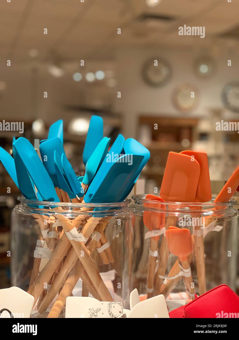 A close-up view of assorted kitchen utensils in various colors stored ...