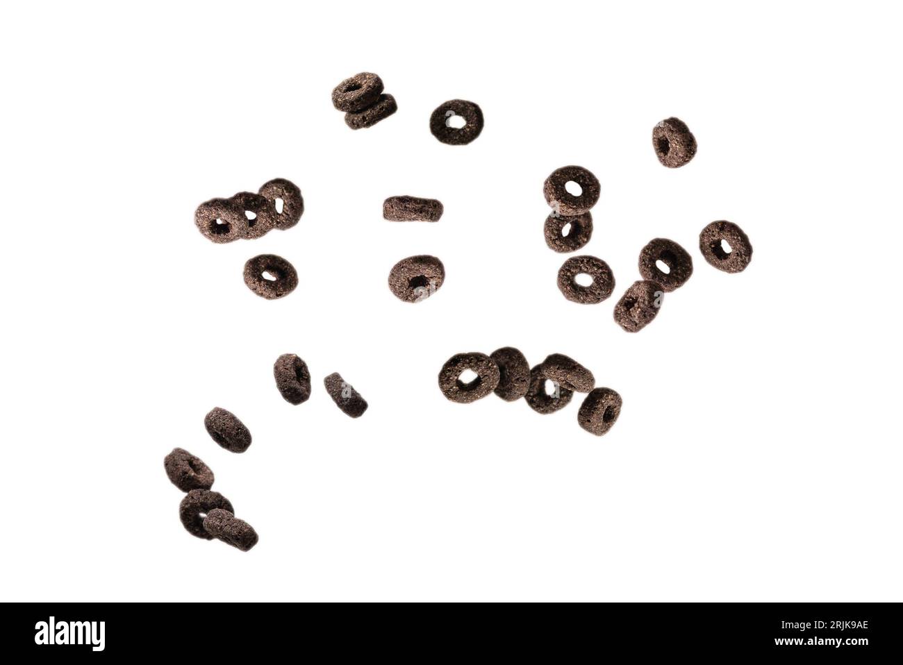Chocolate rings cereal spill out into a bowl. Breakfast. Isolated on a ...