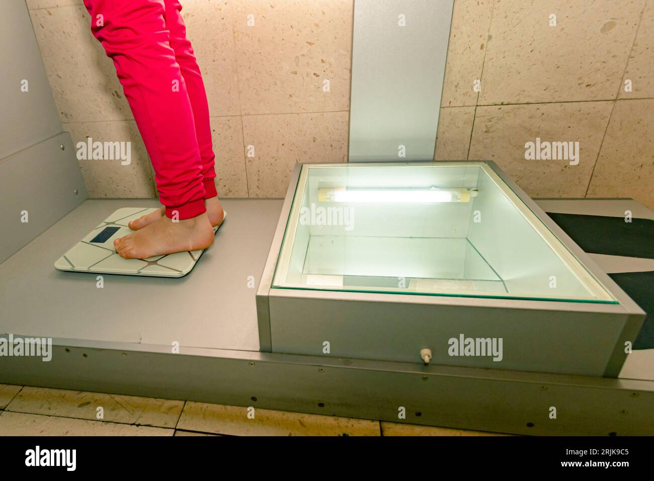 Child's foot is standing on modern floor scale measuring her weight ...