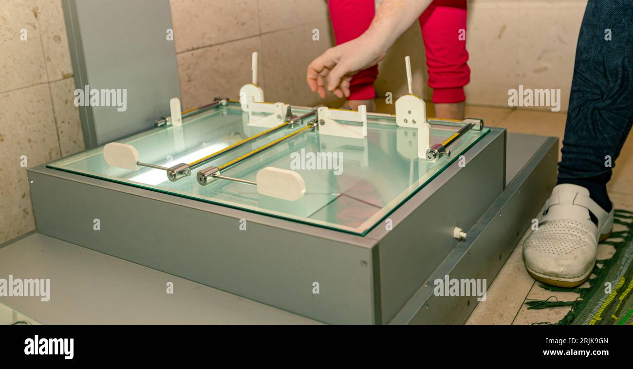 Doctor orthopedist is preparing adjustable metal rulers for foot ...