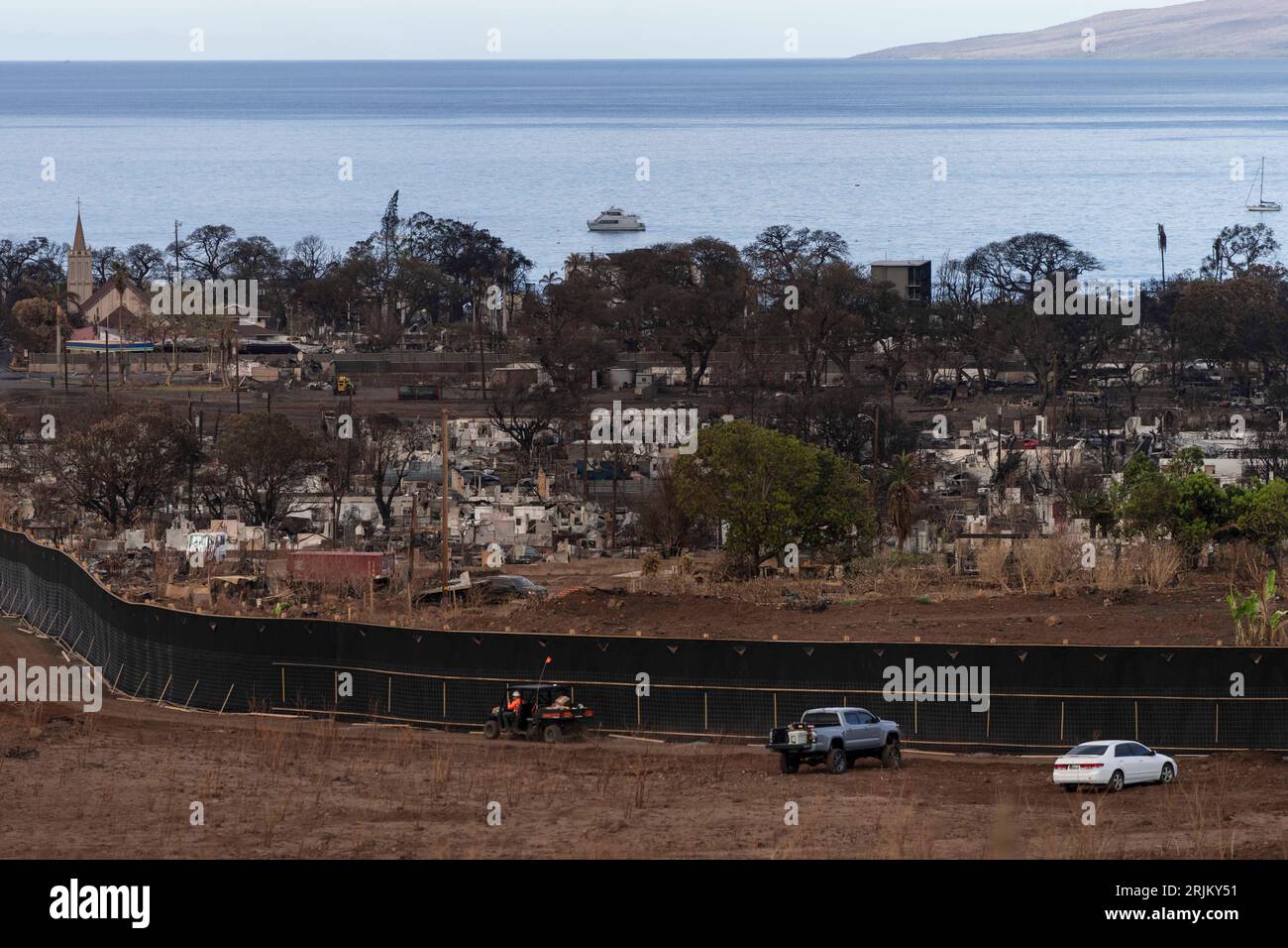 A fence is built around homes consumed by a wildfire in Lahaina, Hawaii ...