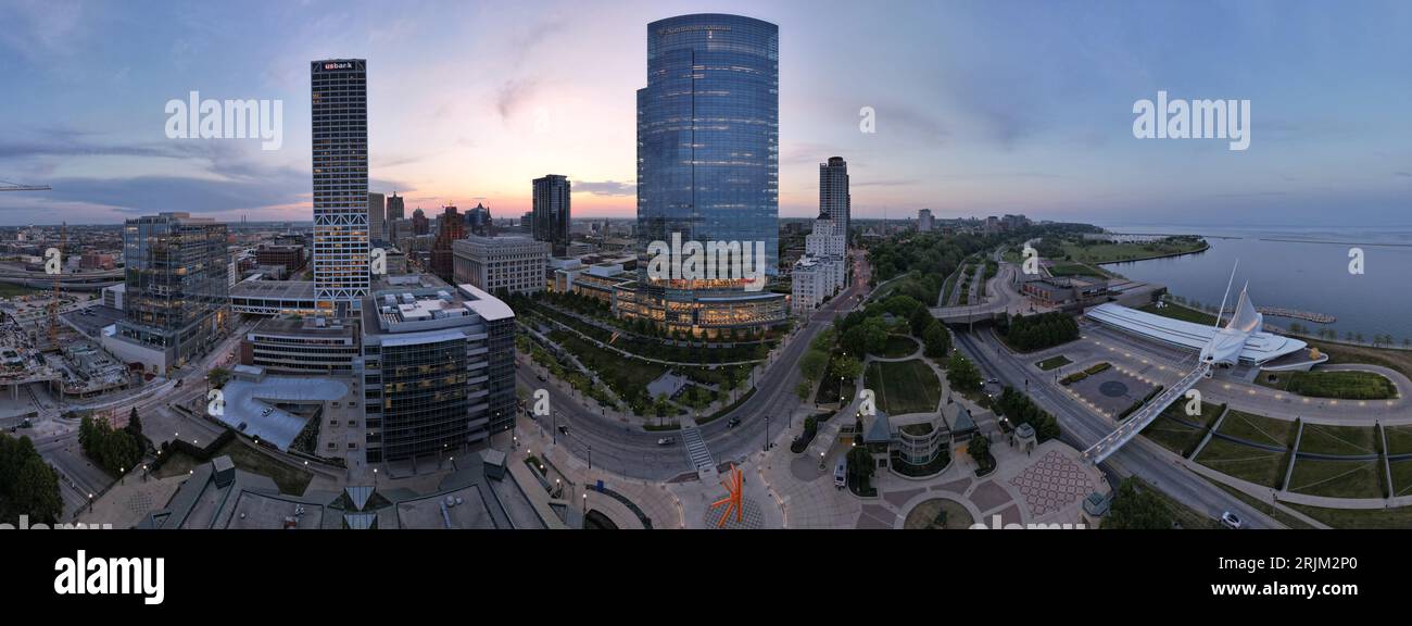 A stunning nightscape of a coastal city skyline with the sun setting ...