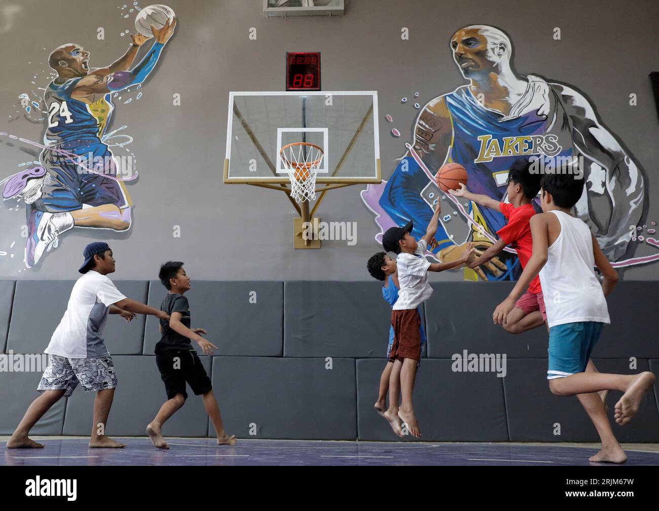 FILE - Boys plays beside images of former NBA basketball player Kobe ...