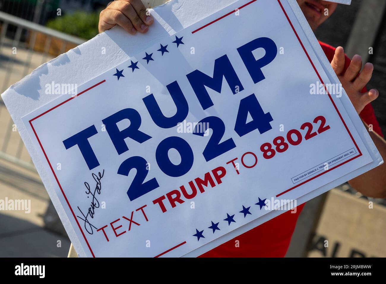 A supporter of former President Donald Trump holds a Trump campaign ...