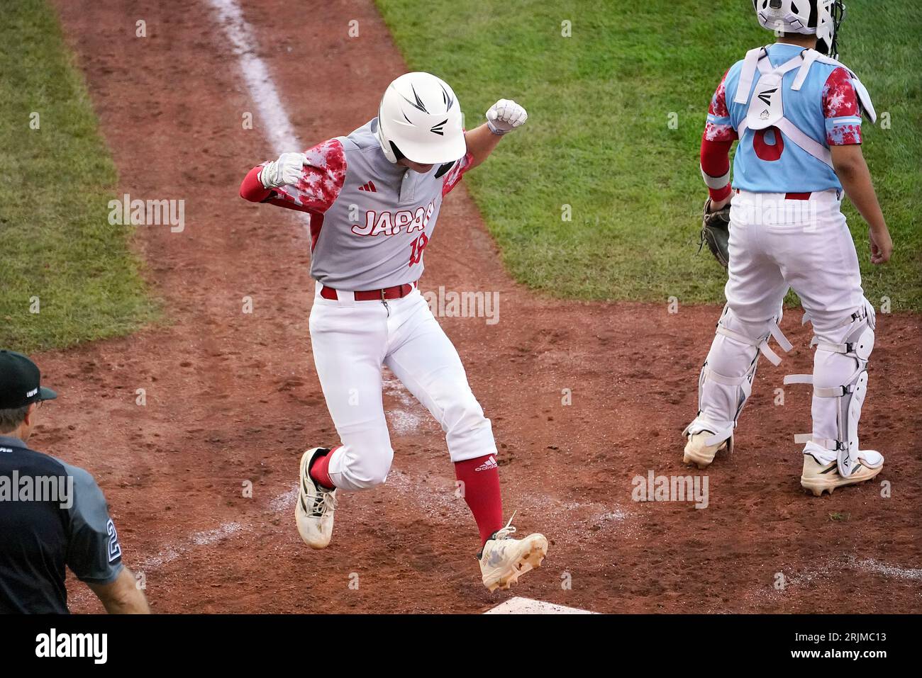 Japan's Yohei Yamaguchi scores on Nobuaki Sakaue's single past Panama's catcher Ian Corrales ...
