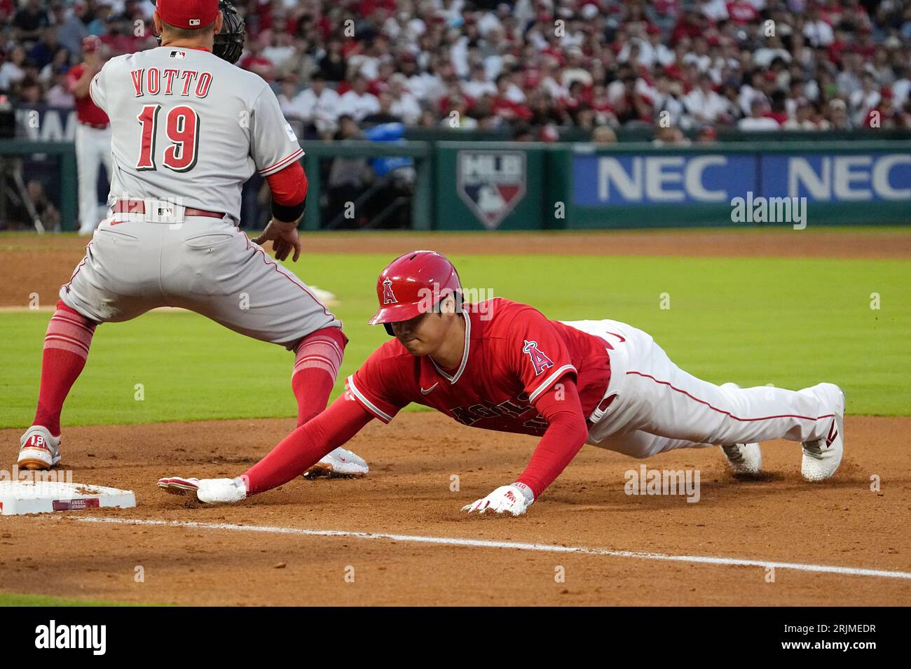 Los Angeles Angels' Shohei Ohtani, right, dives back to first as ...
