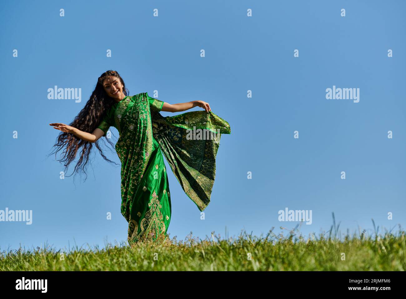 summer dance of cheerful indian woman in traditional attire in green ...