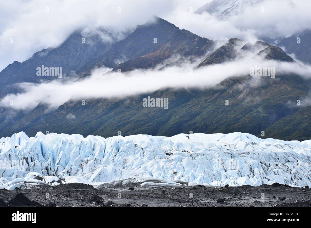 Dramatic landscape featuring an expansive blue glacier set against a ...