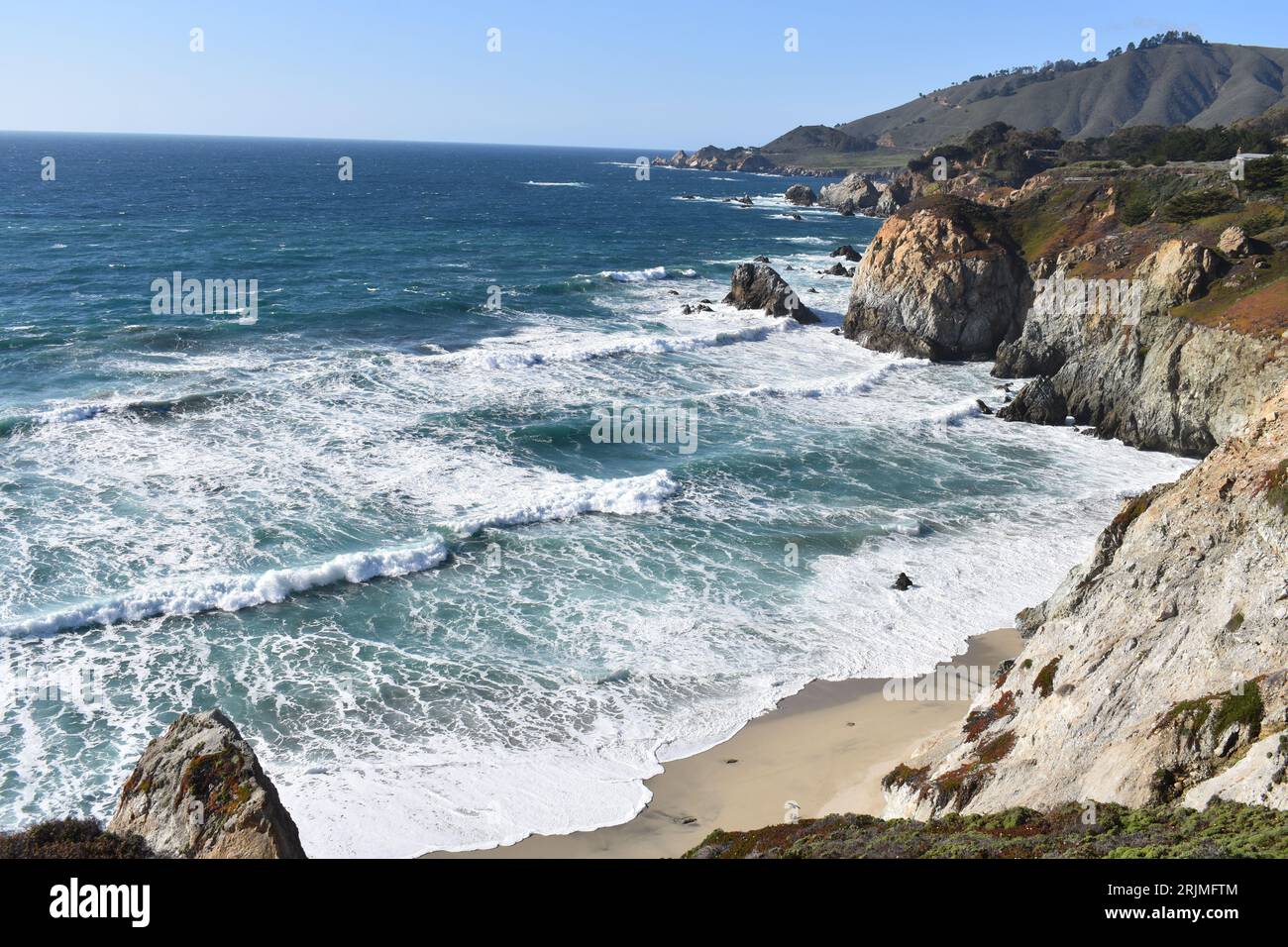 An aerial view of a stunning beach with rolling cliffs and sparkling ...