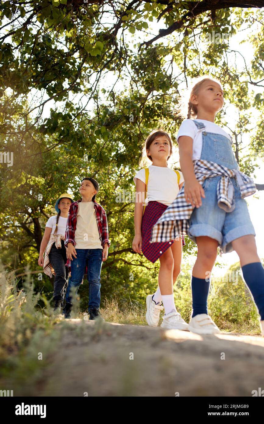 Positive, playful children, boys and girls in casual clothes going ...