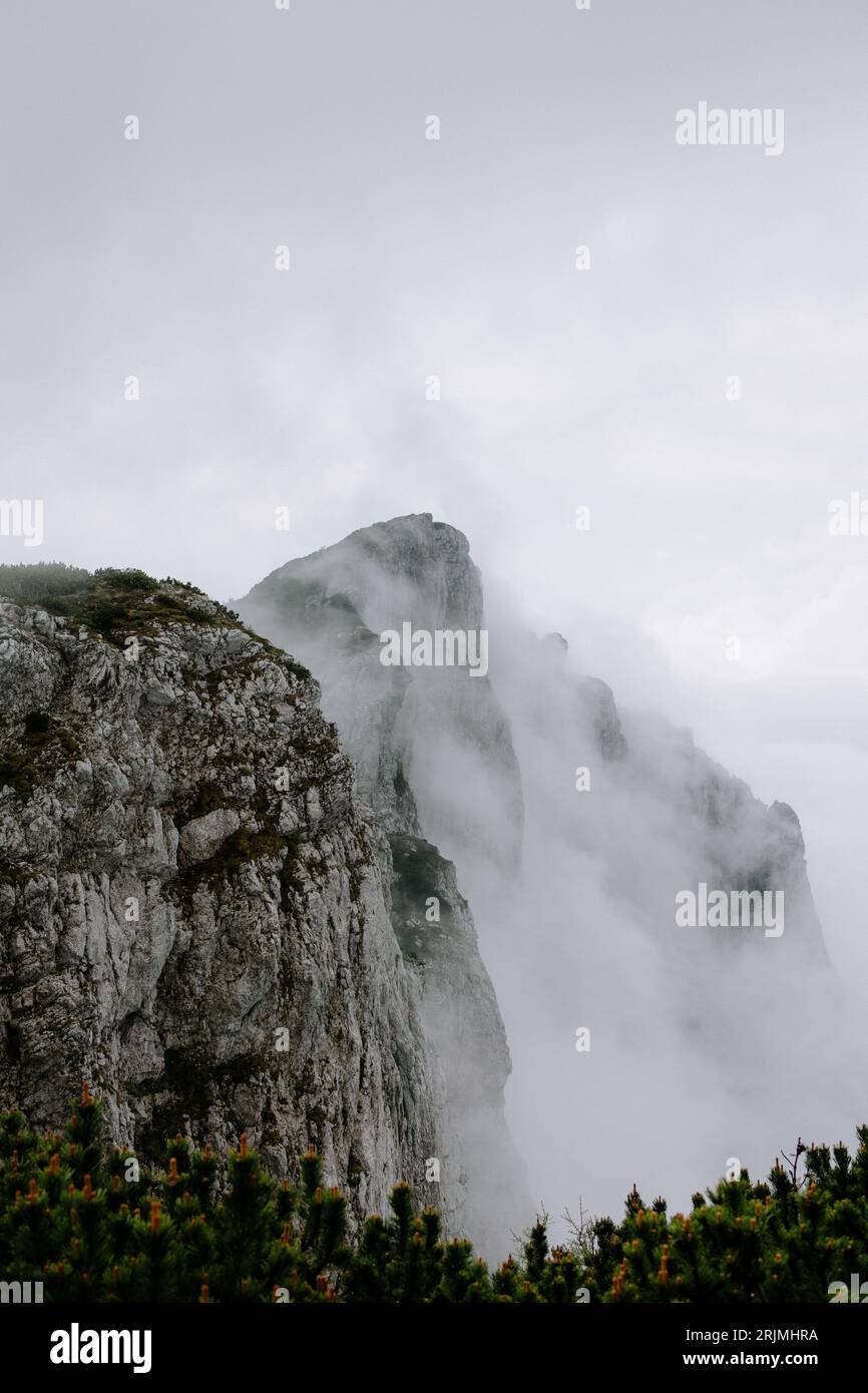A scenic view of a majestic mountain shrouded in mist, creating a ...