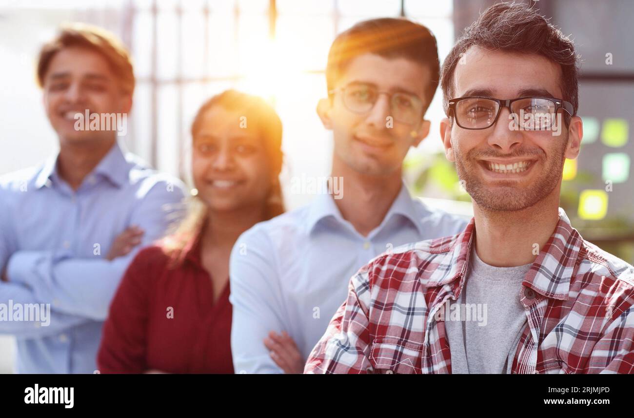 a group of business people smiling in the office lined up with a leader ...