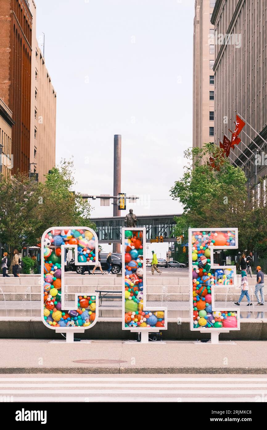 A large sign in a bustling metropolitan area featuring multicolored ...