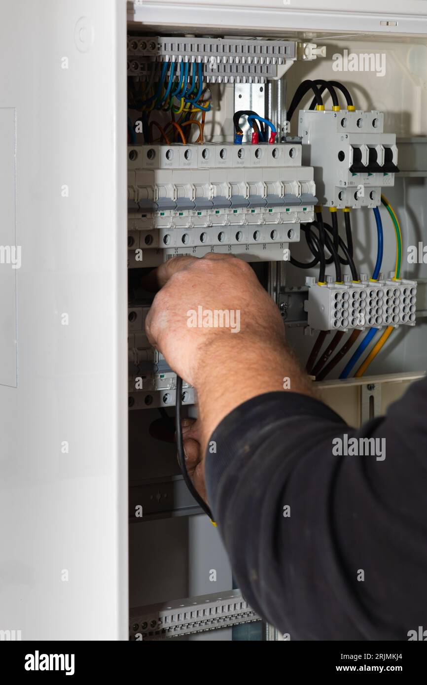An electric technician operating a control panel in a power station ...