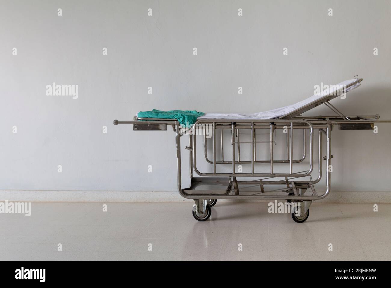 A hospital bed with white sheets and a piece of paper resting on the ...
