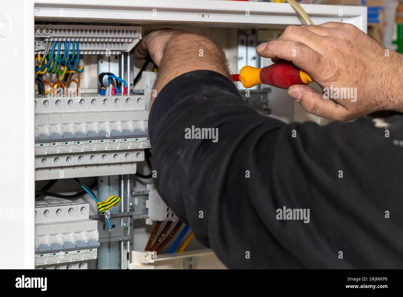 An electric technician operating a control panel in a power station ...
