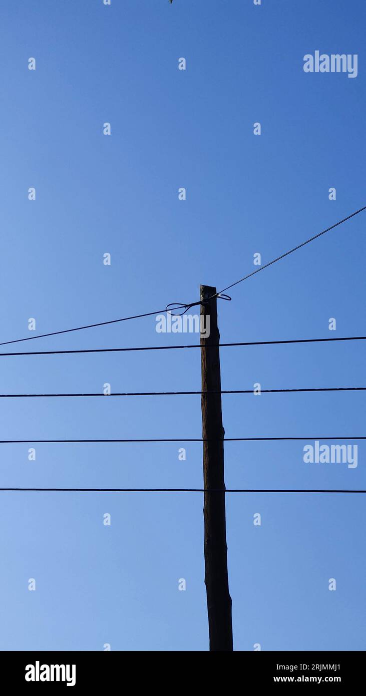 A vertical shot of a tall metal electrical pole with a power lines ...