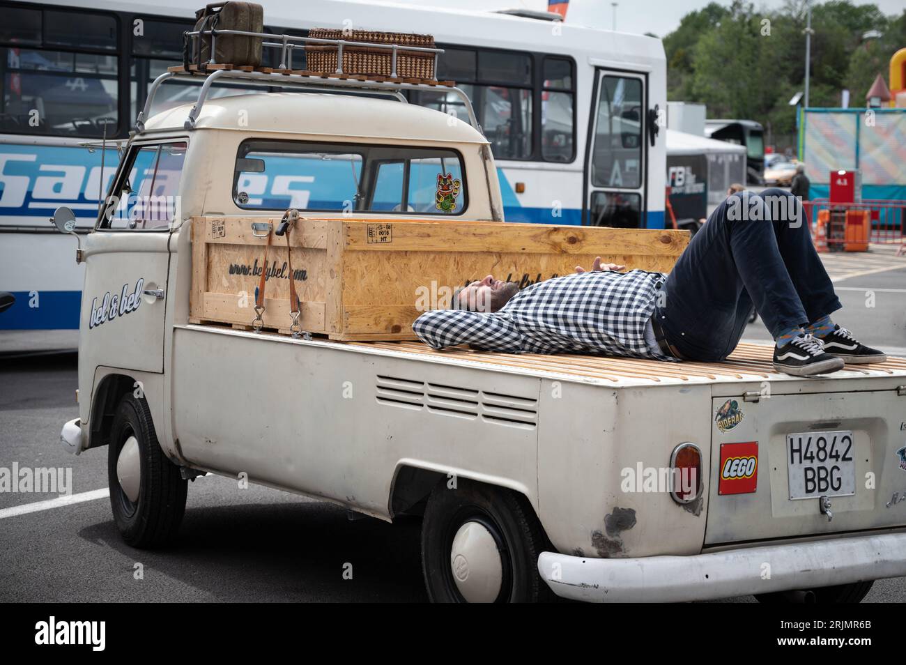 Rear view of an old white Volkswagen T1 pickup van with a man sleeping ...