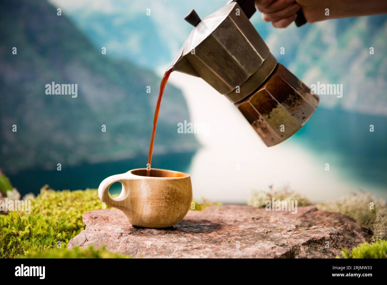 Woman tourist backpacker pouring coffee from a moka coffee maker into a ...