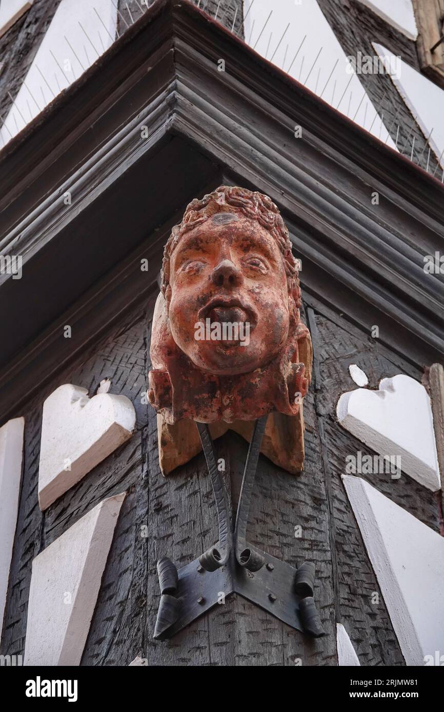 A detailed architectural carving of a human face on the corner of a ...