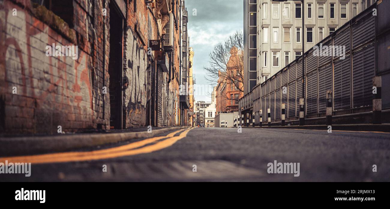 A street in Manchester, featuring an empty road with buildings on ...