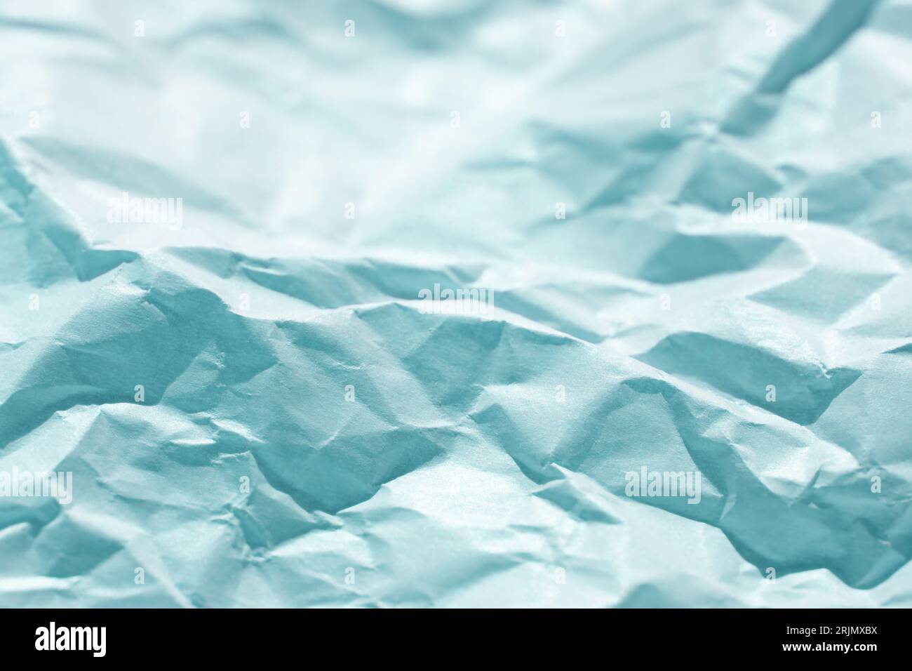 Blank coloured grunge crumpled paper background with folds. A selective ...