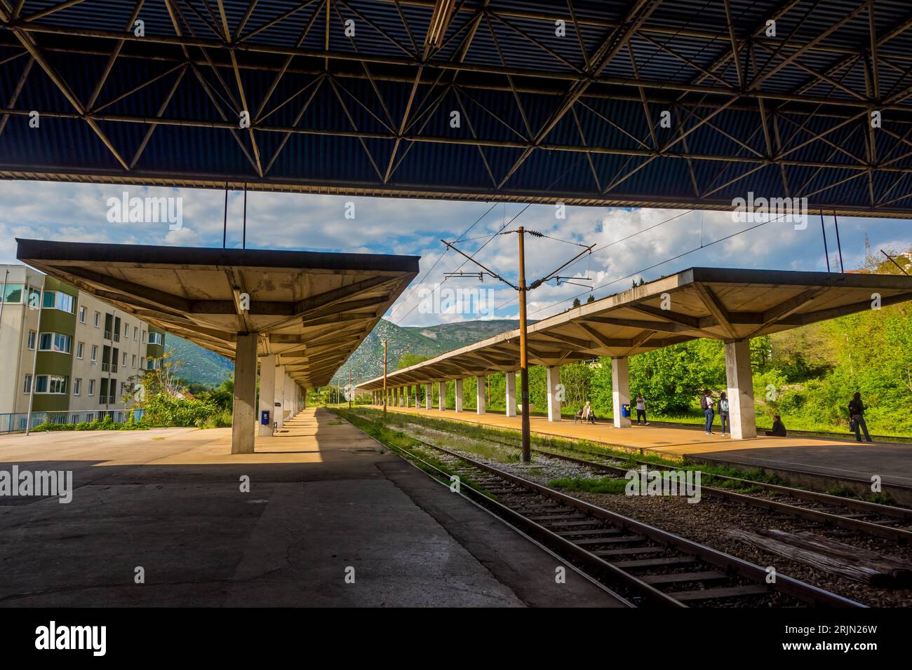 An aged train station featuring railroad tracks and weathered brick ...