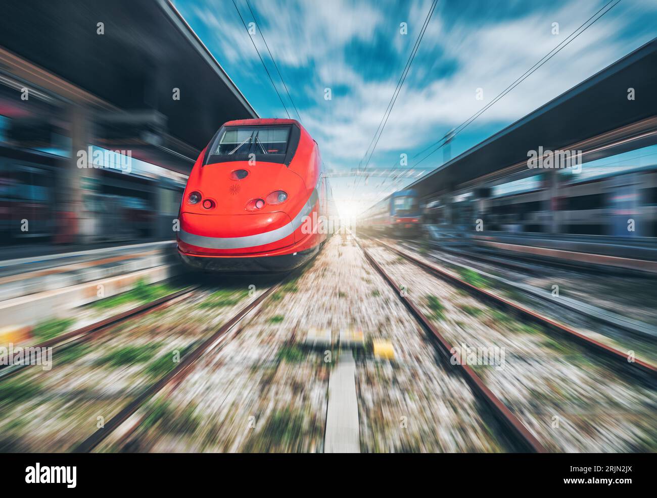 High speed train in motion on the railway station at sunset Stock Photo ...