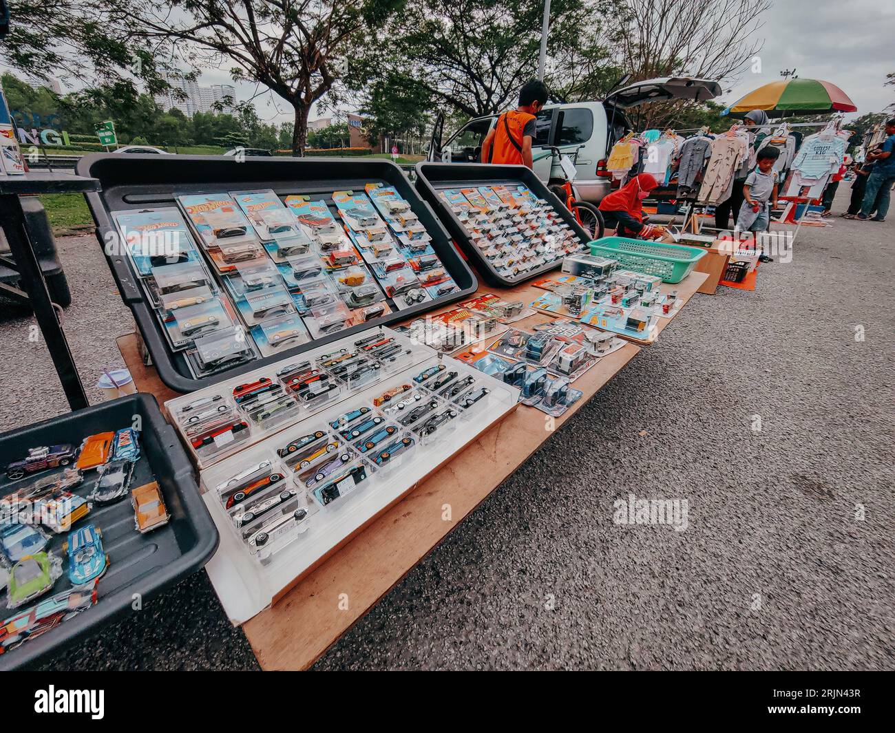 An array of colorful toy cars arranged in a neat line in an outdoor ...