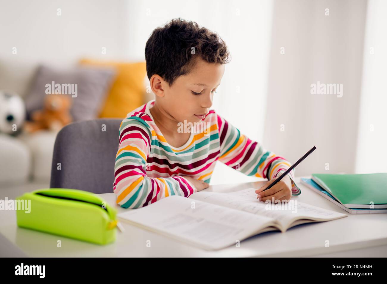 Photo of concentrated school kid sitting table writing copybook prepare ...