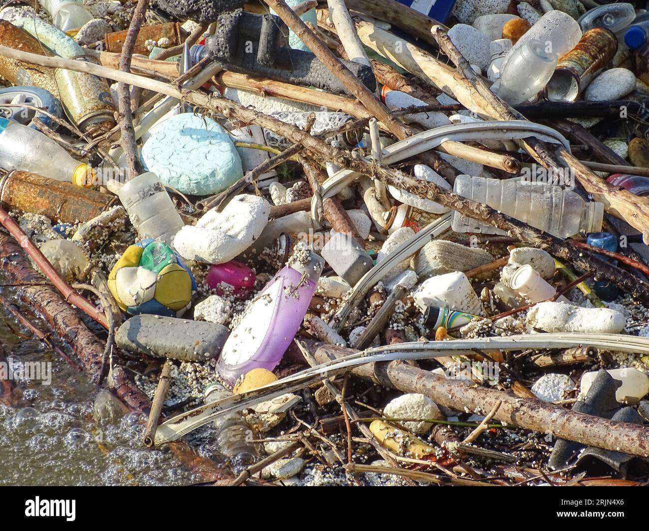 Various rubbish on a river. Waste on the river. Pollution concept Stock ...