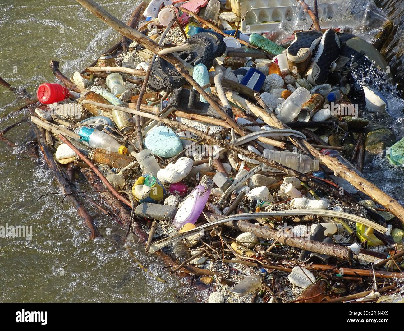 Various rubbish on a river. Waste on the river. Pollution concept Stock ...