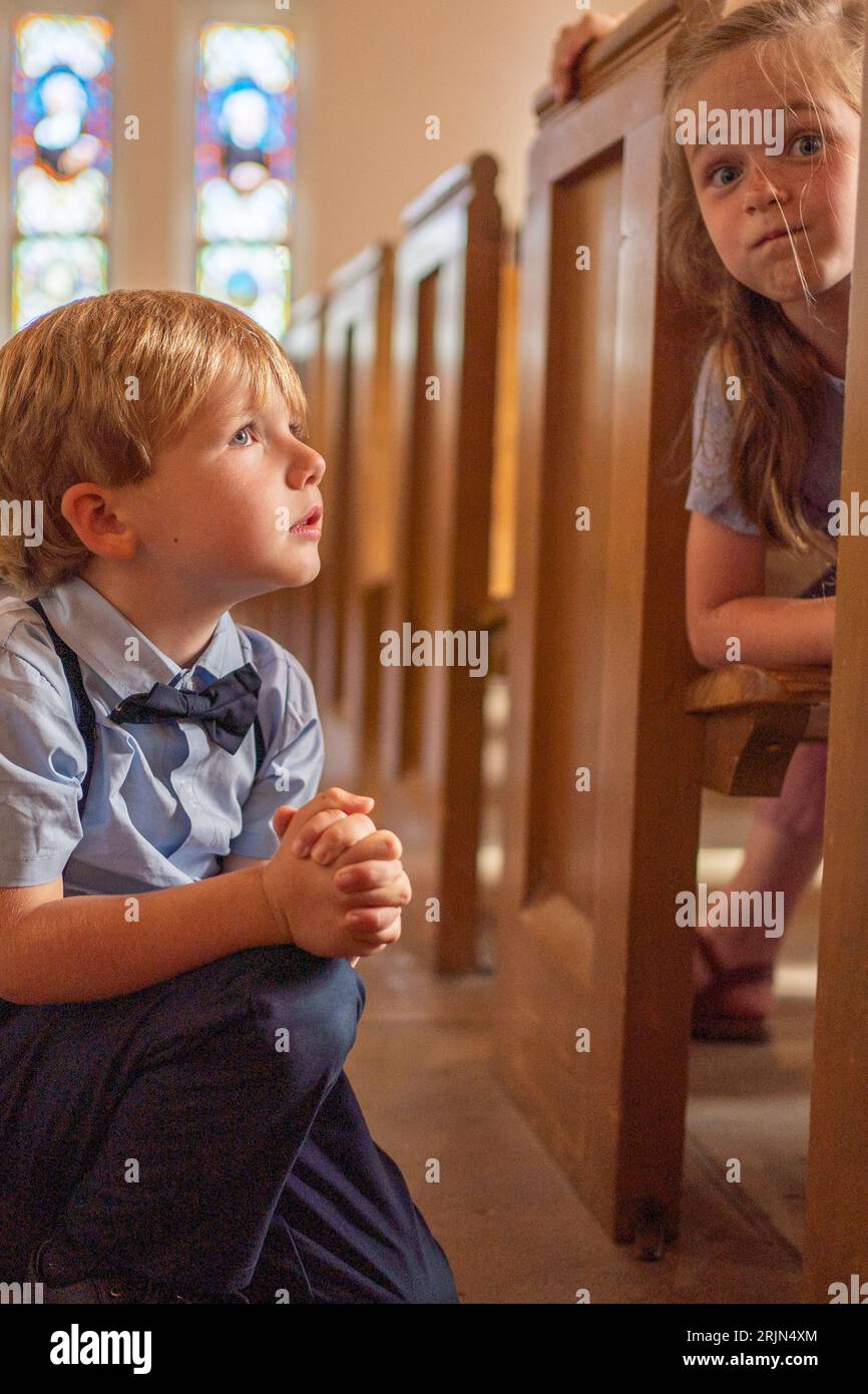 Two children praying hi-res stock photography and images - Alamy