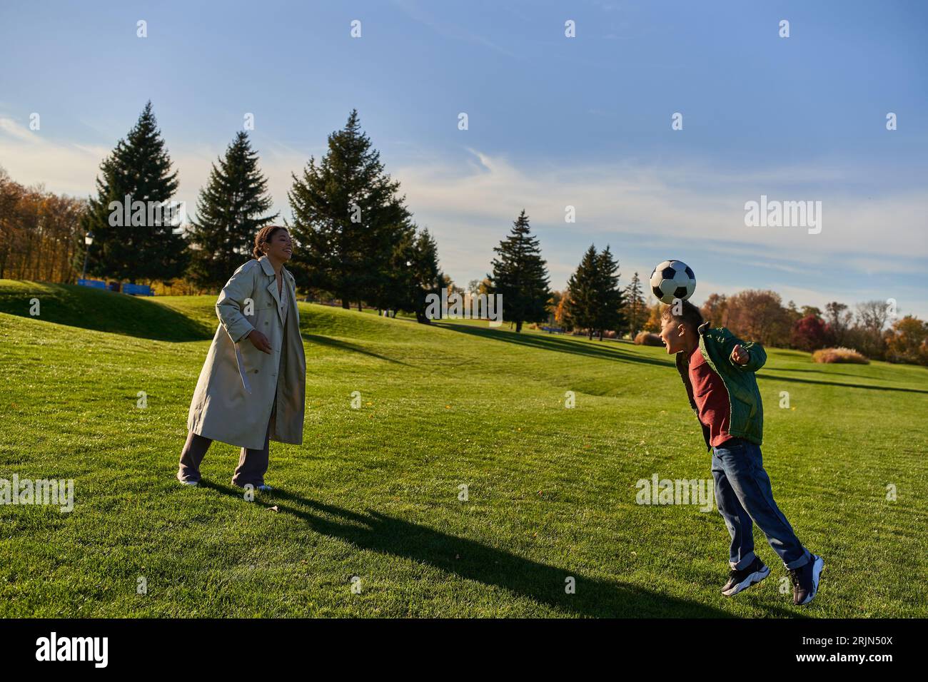 head kick ball, excited african american boy playing football with ...