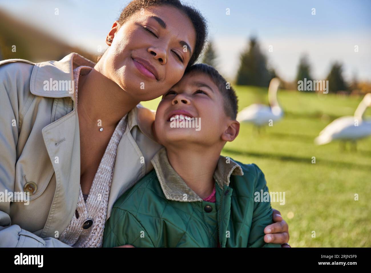 portrait of positive african american woman and boy, mother and son hugging, bonding and love ...