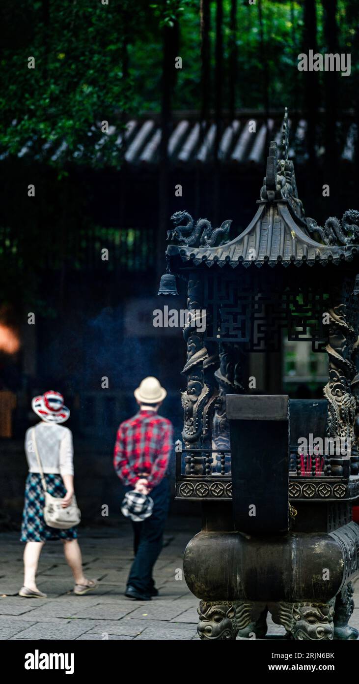 A group of people passing a statue in an outdoor setting Stock Photo ...