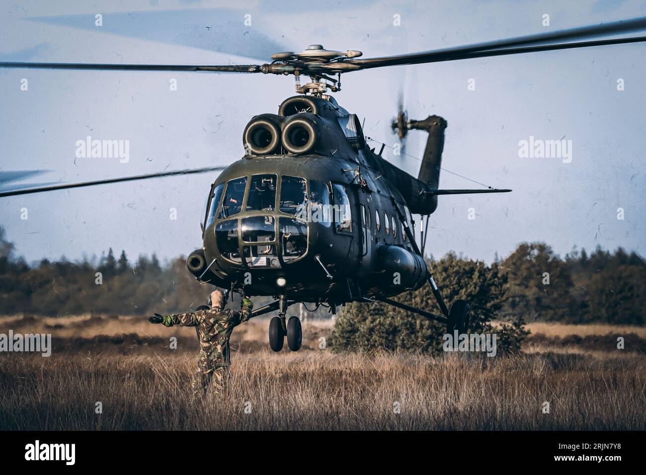 A military helicopter soaring through the air, with other personnel ...