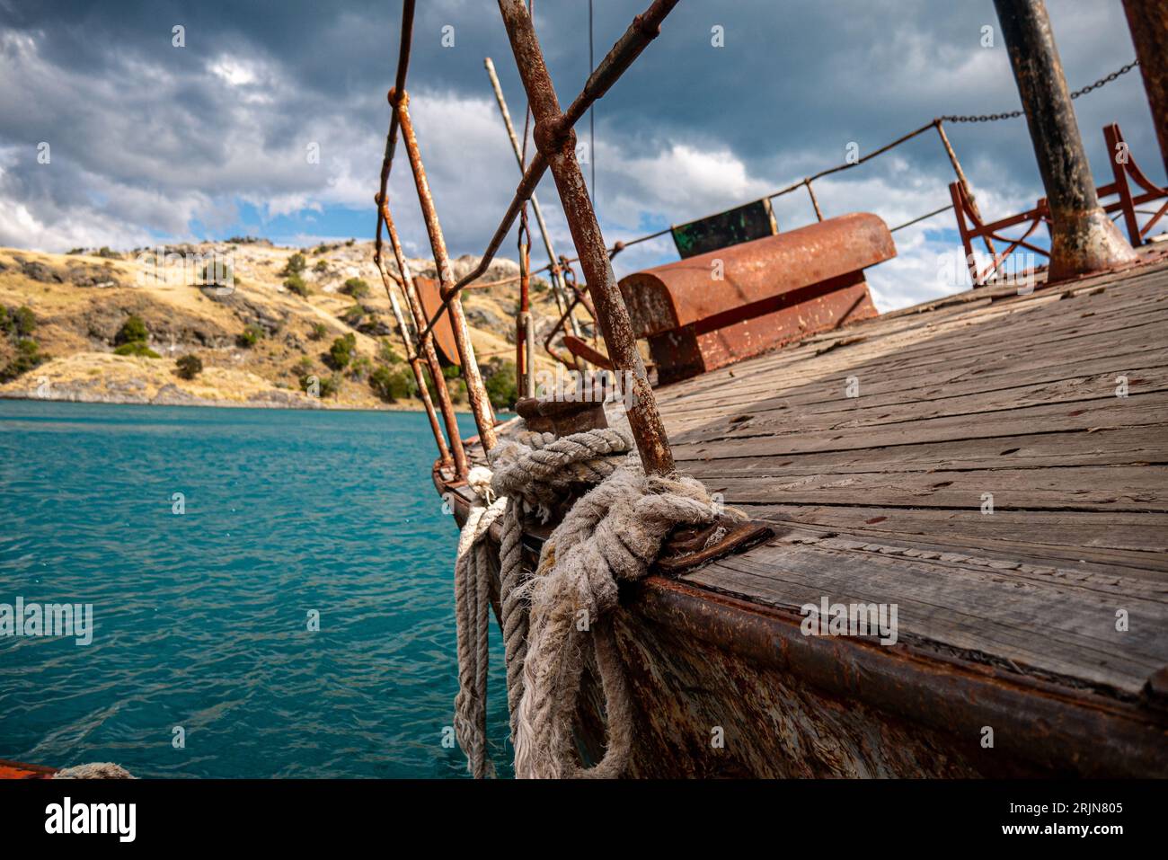 A close-up of a boat with a thick rope tied in a knot around the boat's ...