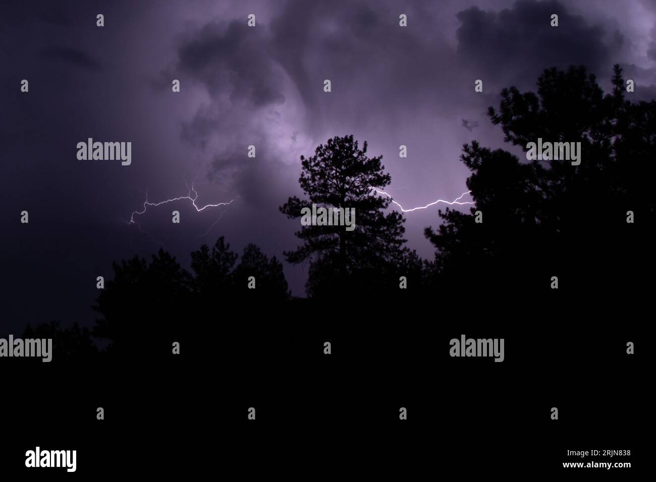 A dramatic scene of a thunderstorm illuminated by a streak of lightning ...